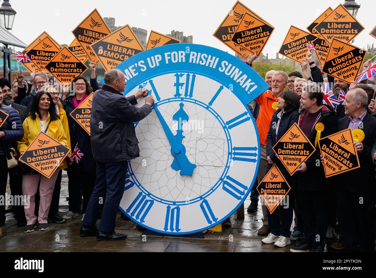 Leader of the Liberal Democrats Sir Ed Davey moves the hands of a clock ...