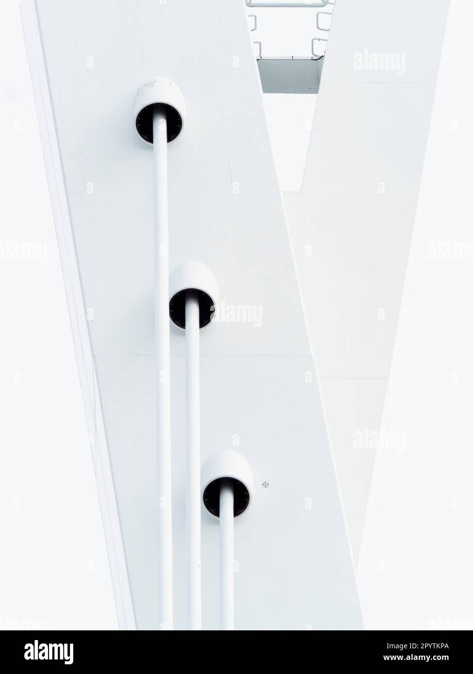 A closeup of white suspension cables on a metal structure on white ...