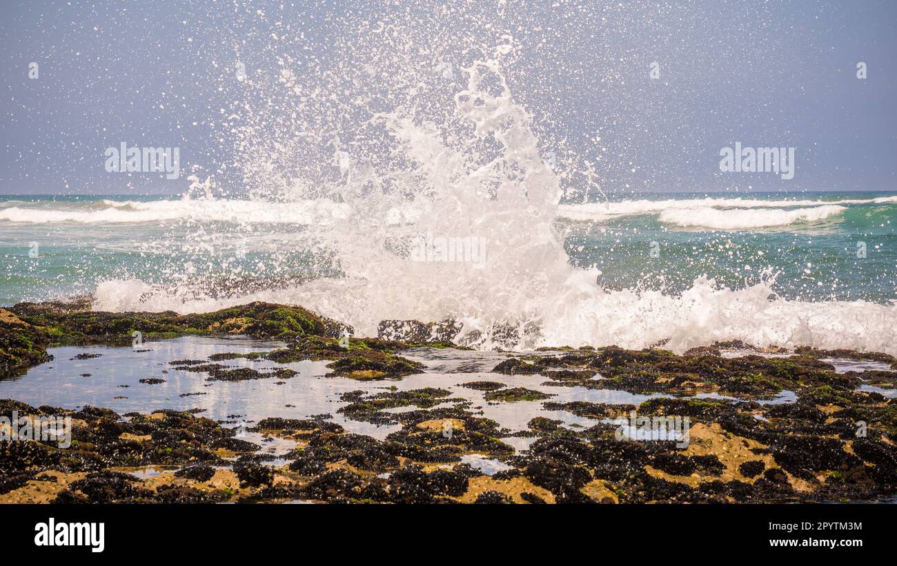 Atlantic Ocean in Morocco, water splashing on the rocks on a windy day ...