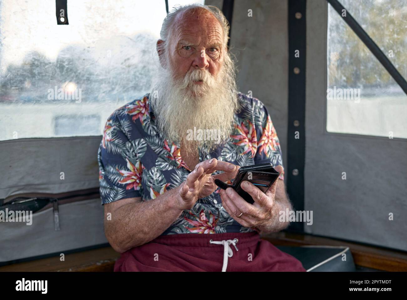 Portrait of 76 year old man now living contented aboard a narrow boat ...