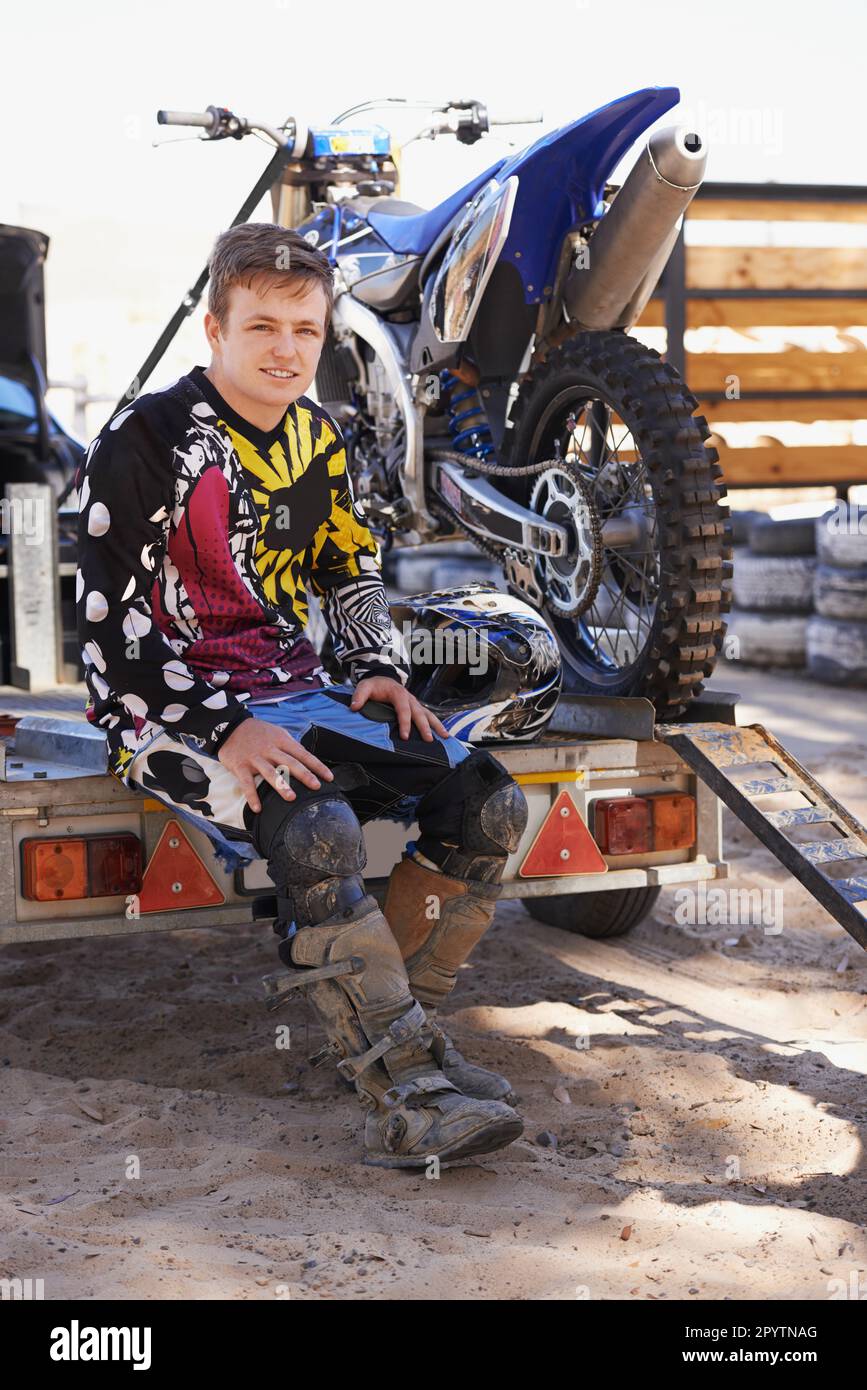 Ready to take on anything. Portrait of a young dirt bike racer sitting ...