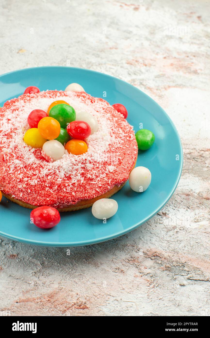 front view delicious pink cake with colorful candies inside plate on ...
