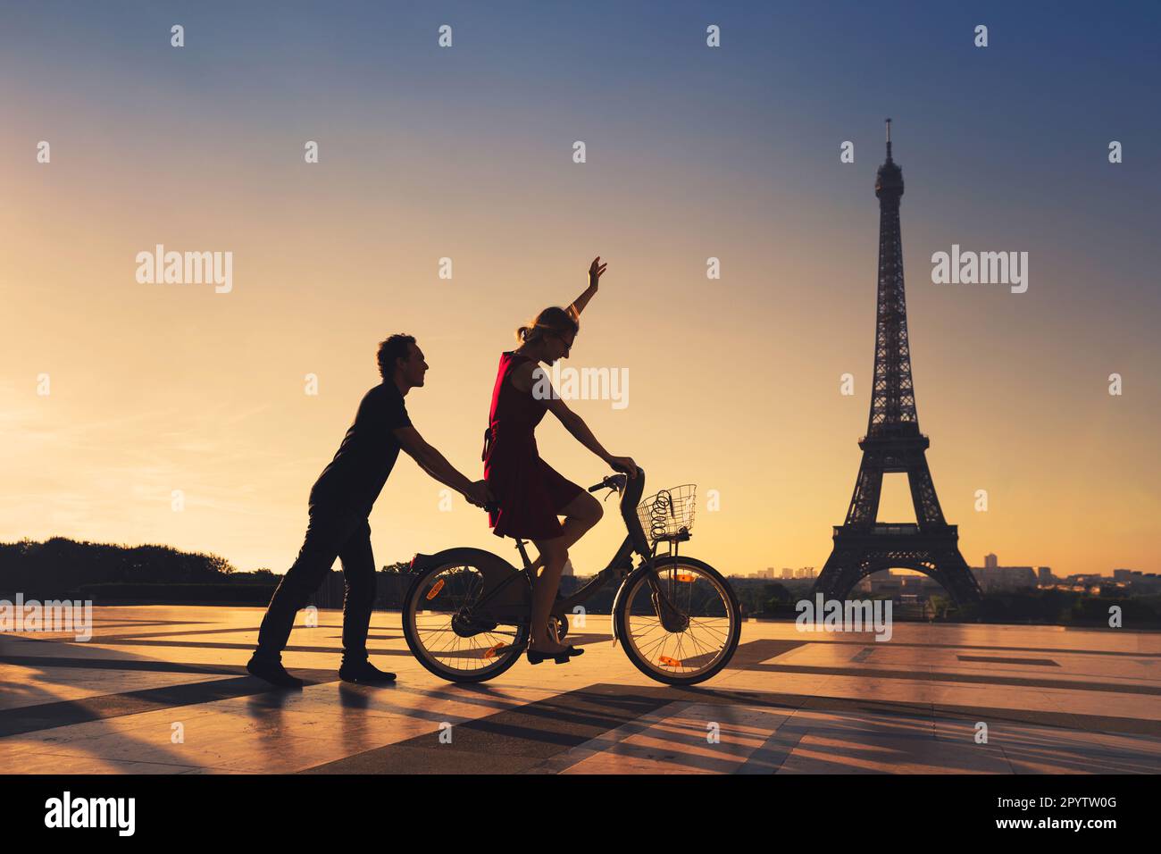 happy couple having fun in Paris riding bicycle near Eiffel tower ...