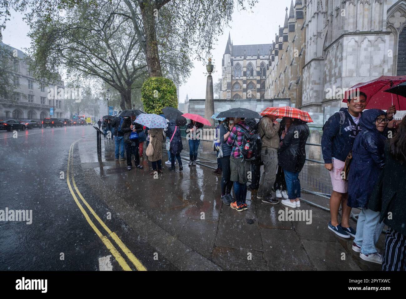 London UK. 5 May 2023. Pedestrians and royal fans are caught in a heavy ...