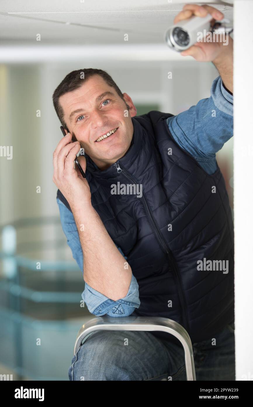 technician installing a cctv on the ceiling Stock Photo - Alamy
