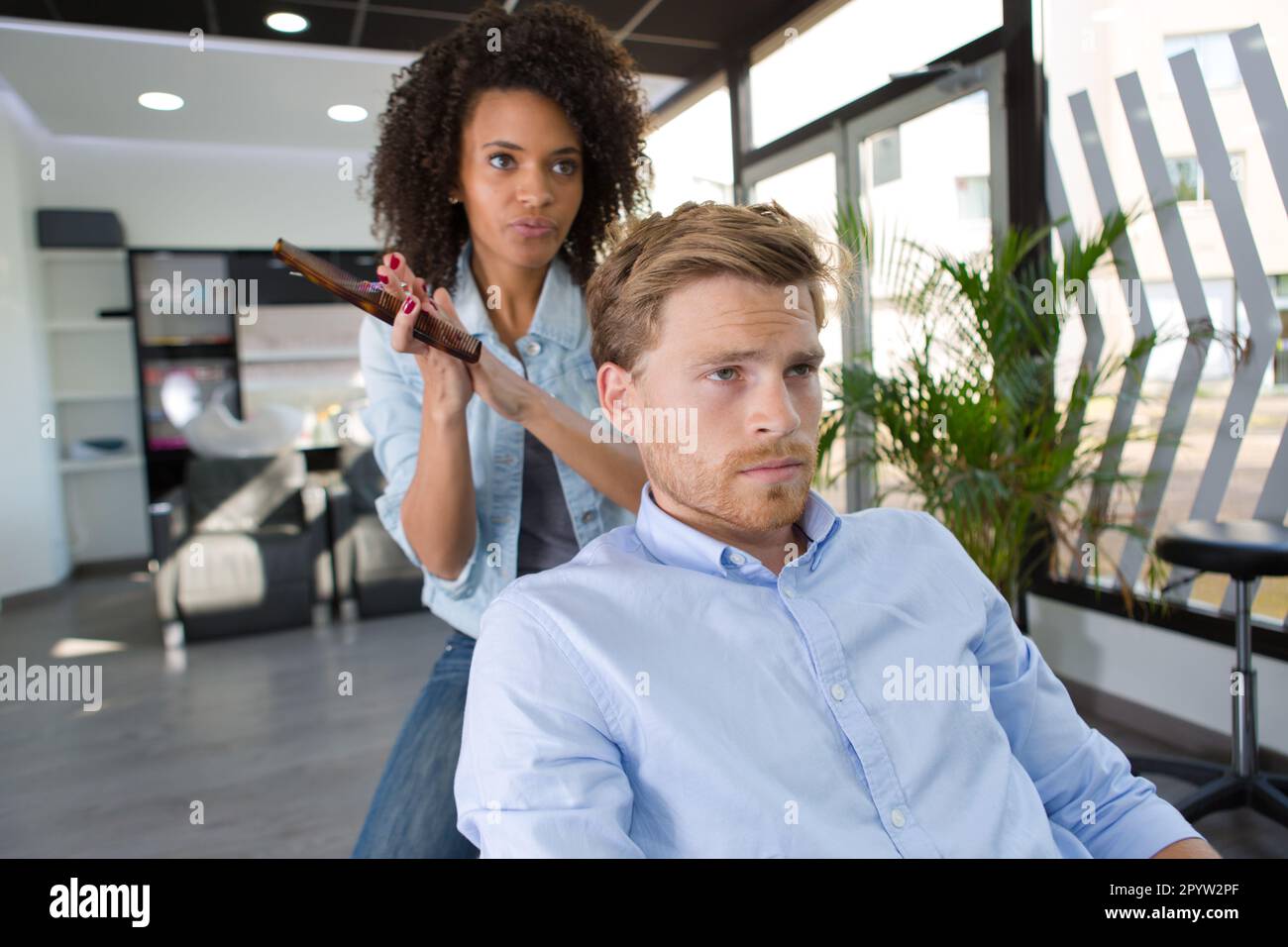 female haidresser talking to male client in salon chair Stock Photo - Alamy
