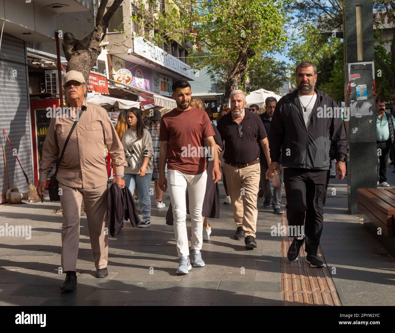 Turkish men of different ages walk down a bustling shopping street in ...