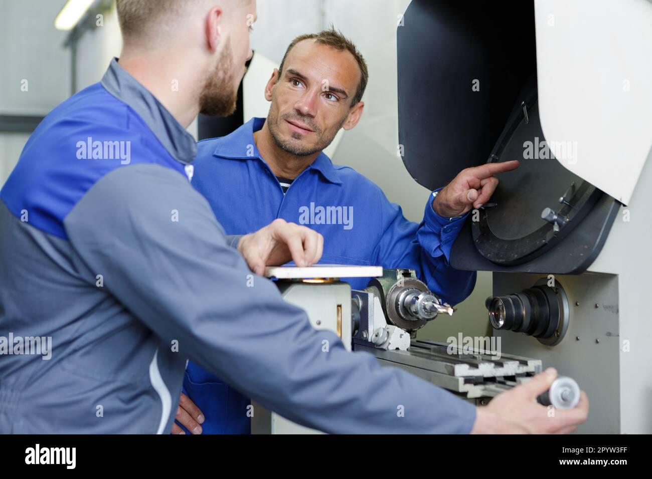 two happy positive mechanics working at workshop Stock Photo - Alamy