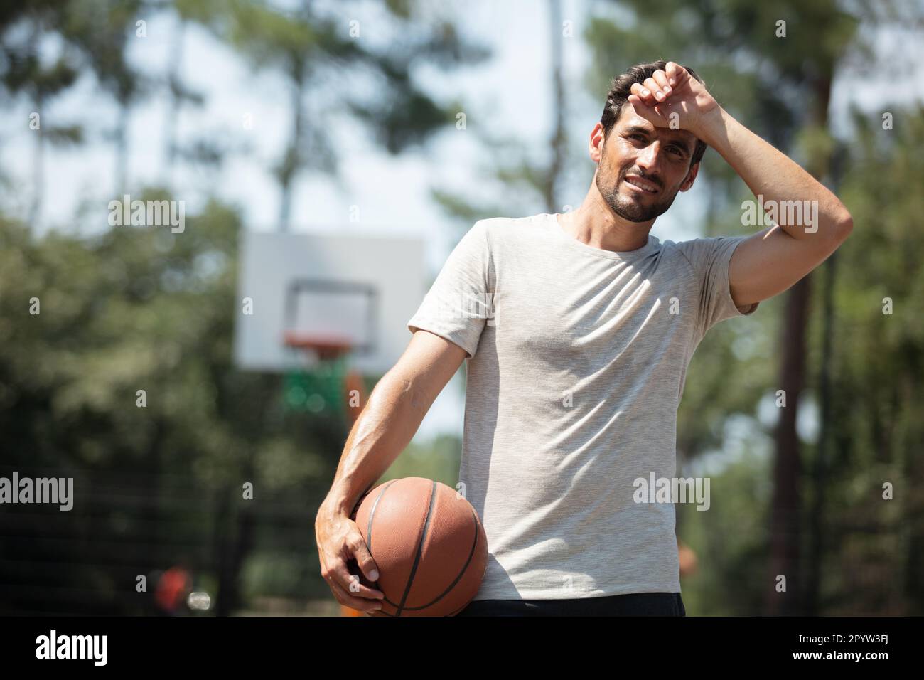 tired basketball player with ball on outdoor court Stock Photo - Alamy