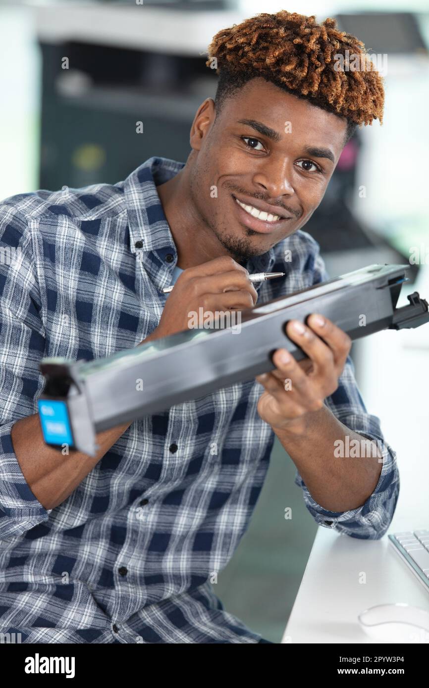 happy young man fixing a printer Stock Photo - Alamy