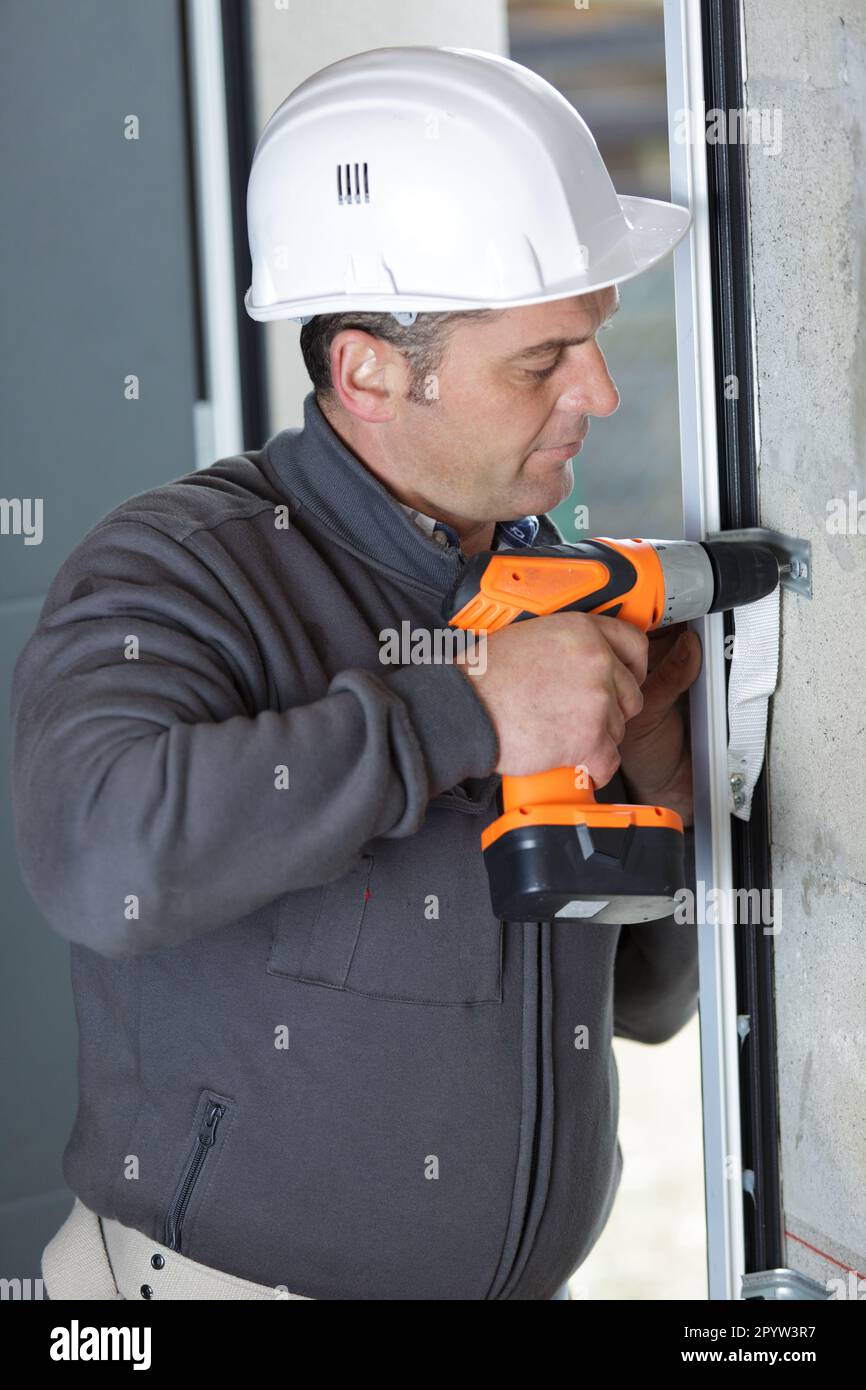 happy man drilling the wall with drill perforator Stock Photo - Alamy