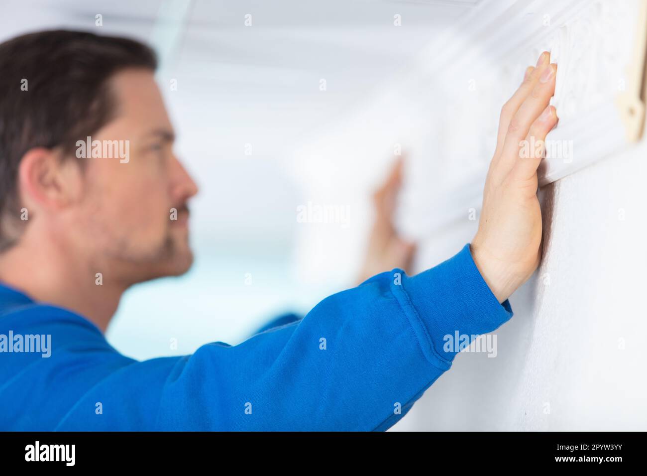 builder man measuring wall with flexible ruler Stock Photo - Alamy