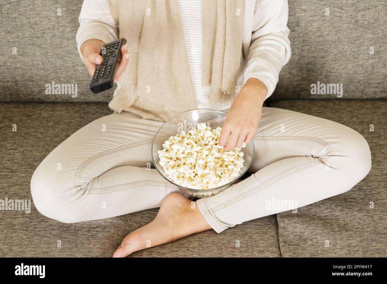 partial view of person eating popcorn from glass bowl Stock Photo - Alamy