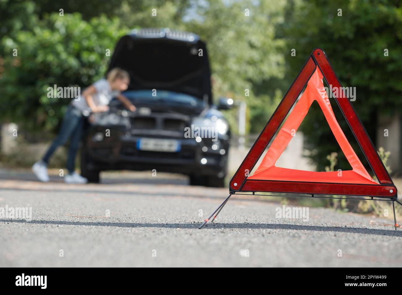 triangle on floor with woman looking at breakdown car Stock Photo - Alamy