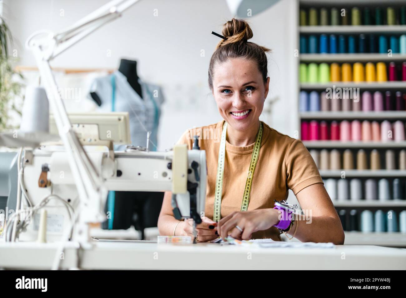 Fashion designer using a sewing machine at her workplace Stock Photo ...