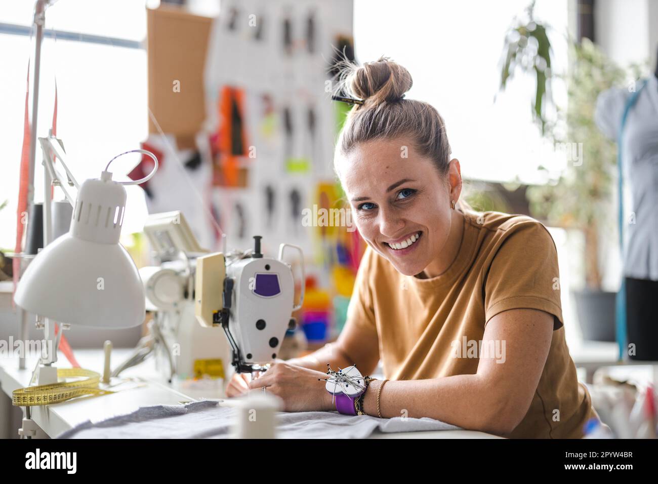 Fashion designer using a sewing machine at her workplace Stock Photo ...