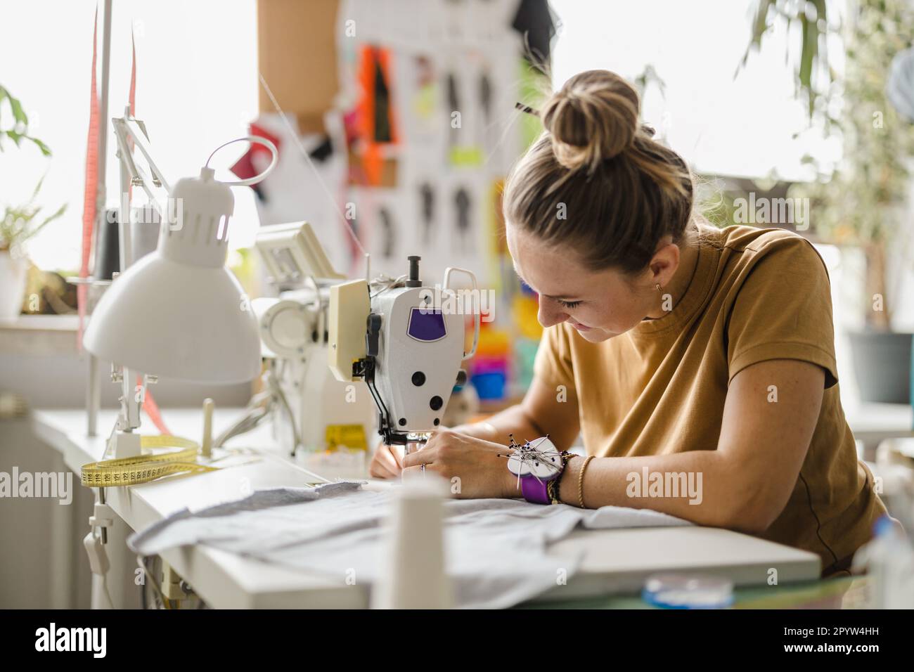 Fashion designer using a sewing machine at her workplace Stock Photo ...