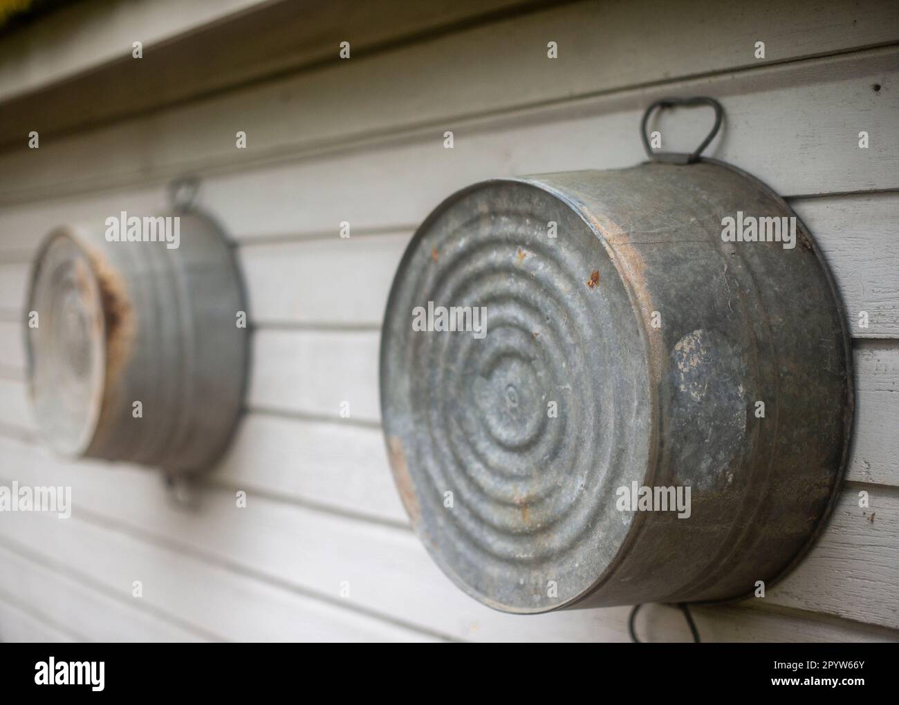 Two metal basins hanging on the wall of an old barn Stock Photo - Alamy