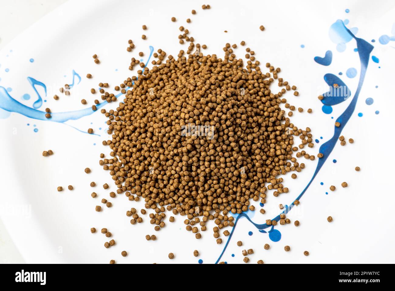 Pile of compound feed small round isolated on white plate. Organic feed ...