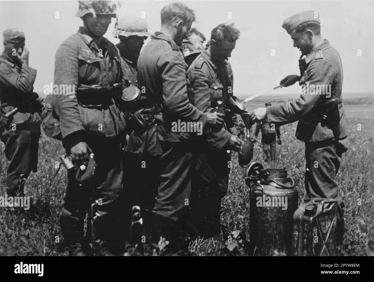 Soldiers fill their water bottles from a water barrel during fighting ...