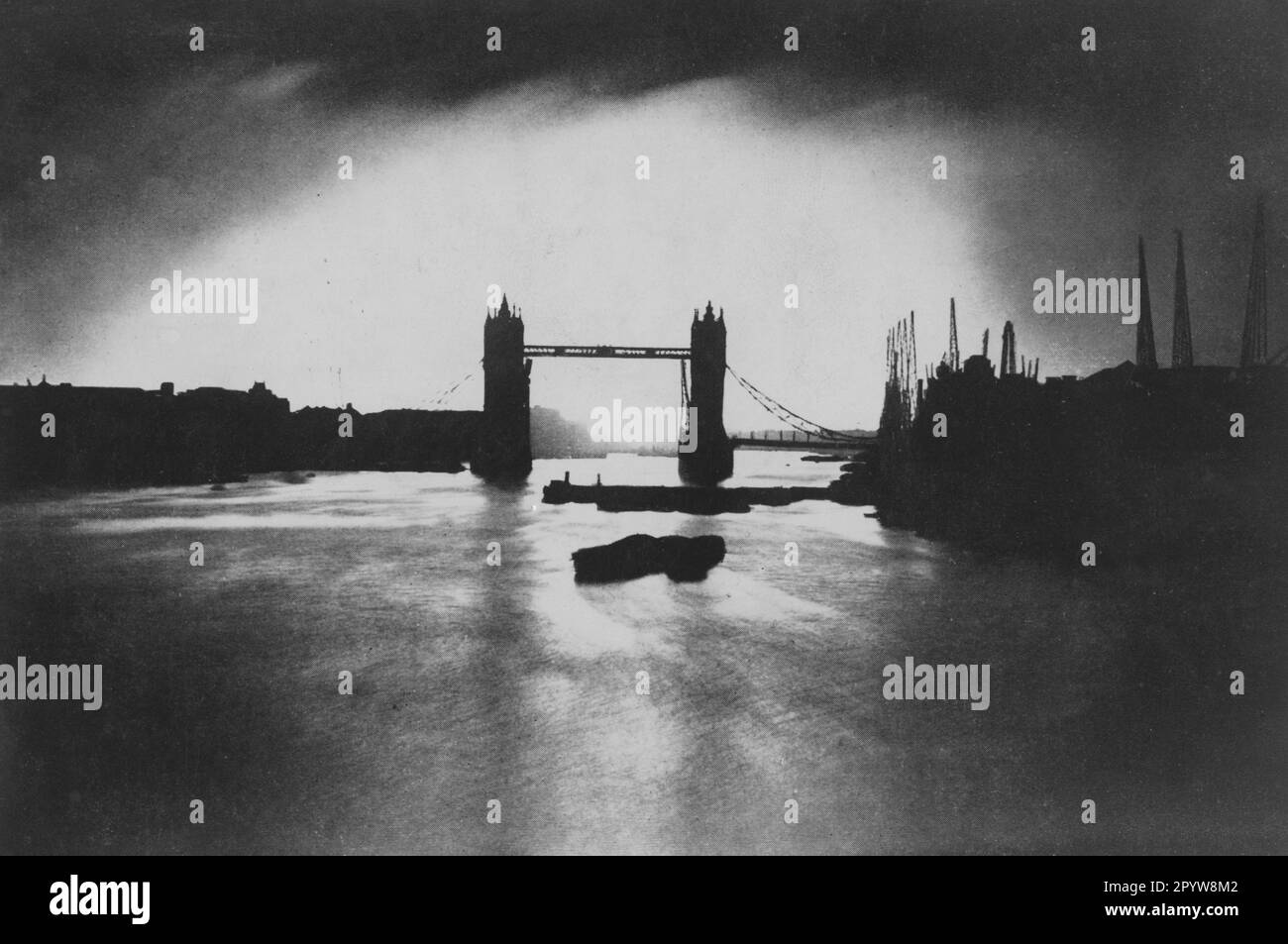 View across Tower Bridge of pockets of fire after a bombing raid during ...