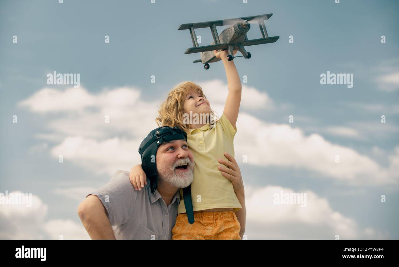 Grandfather and son enjoying play with plane together on blue sky. Cute ...