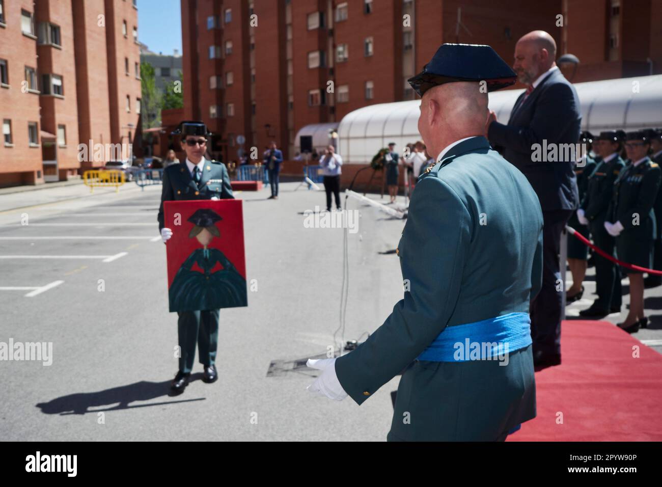 A Guardia Civil officer hands over a painting of a "menina" dressed as ...