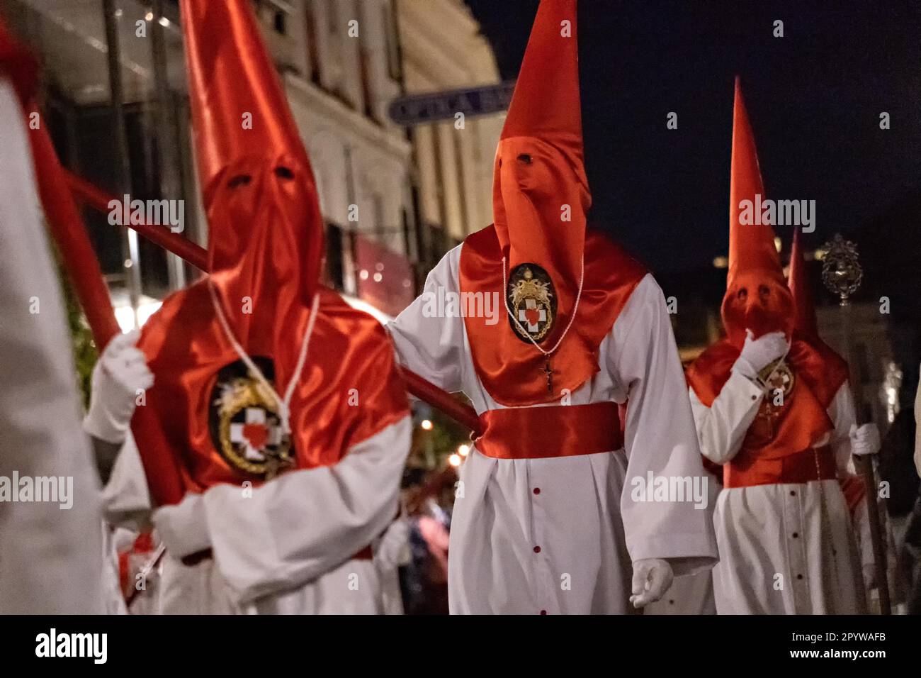 Cofradias wearing red cone shaped hoods walk through the streets during ...