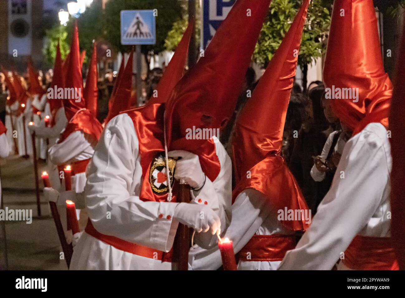 Cofradias wearing red cone shaped hoods light their candles during the ...
