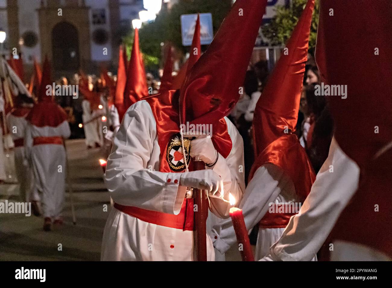 Cofradias wearing red cone shaped hoods light their candles during the ...