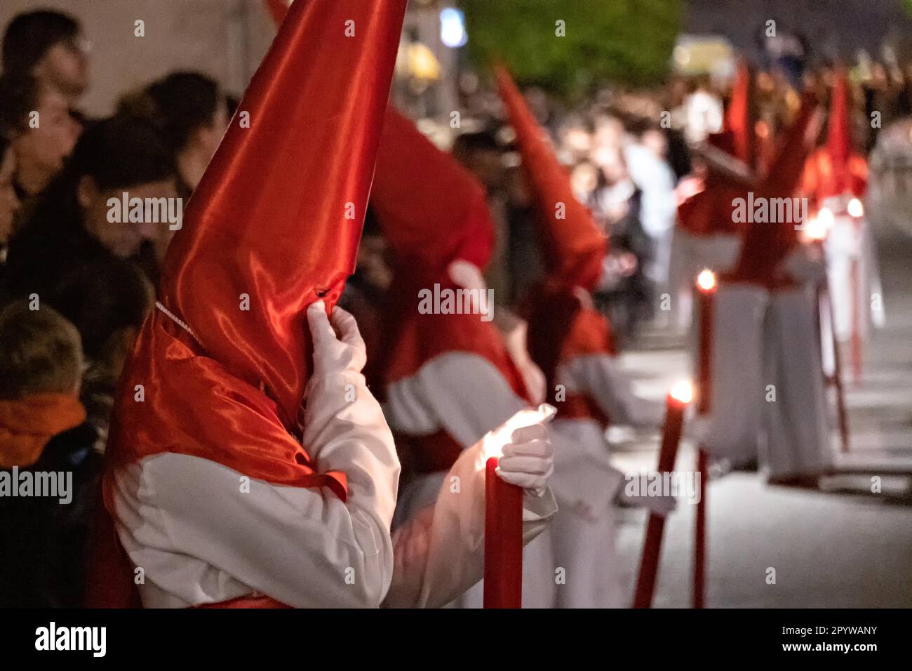 A Cofradia wearing a red cone shaped hood rubs his eyes during the ...