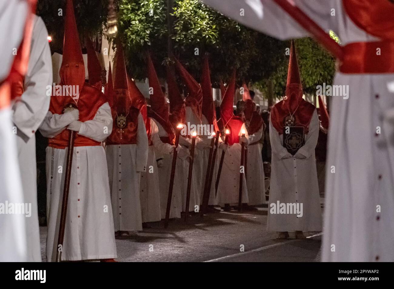 Cofradias wearing red cone shaped hoods walk through the streets during ...