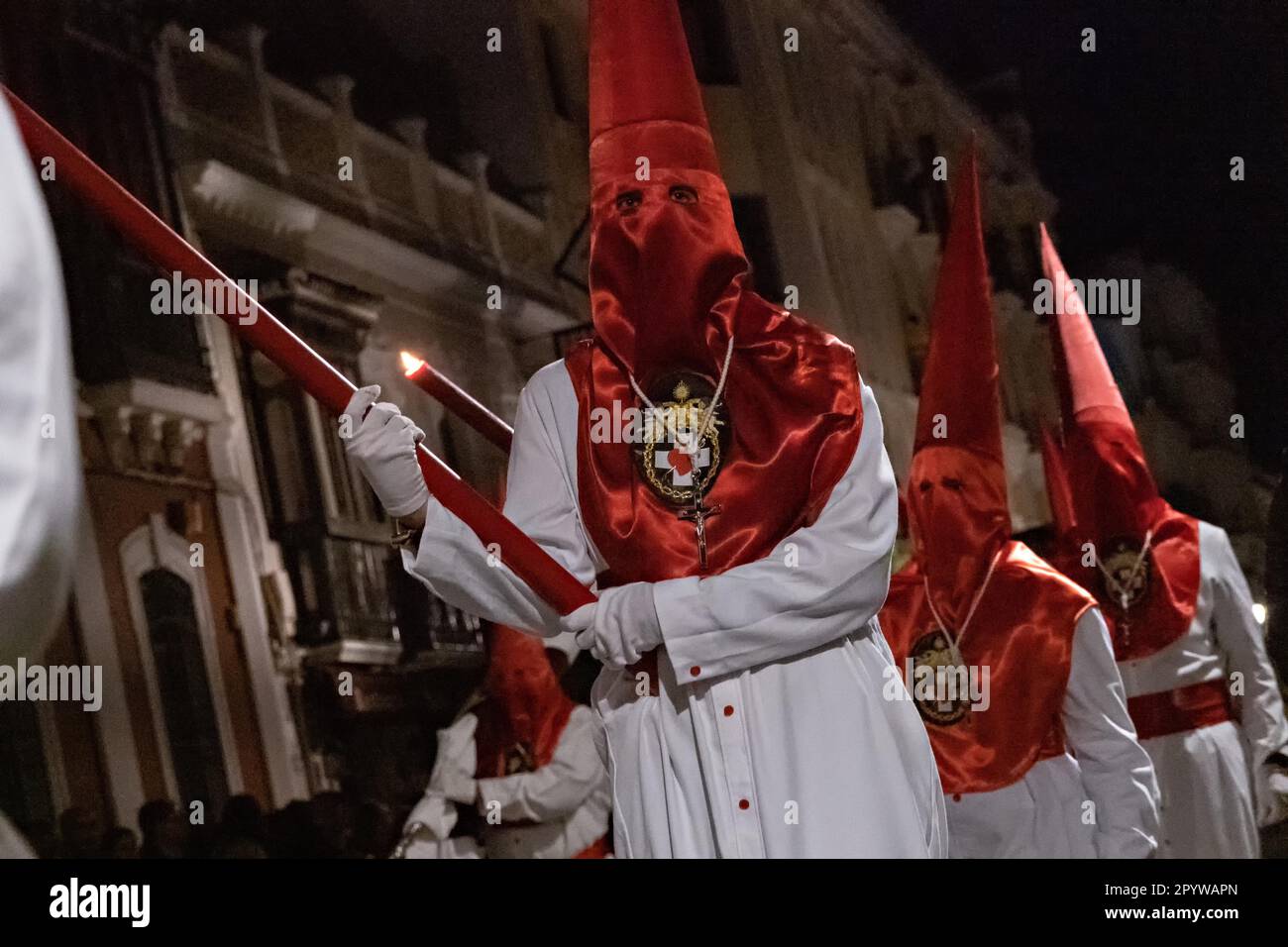Cofradias wearing red cone shaped hoods walk through the streets during ...