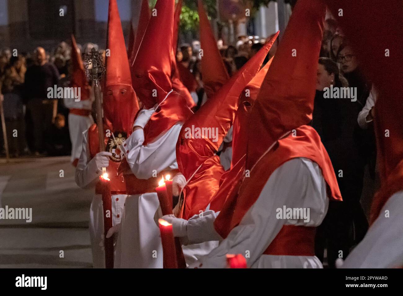 Cofradias wearing red cone shaped hoods walk through the streets during ...