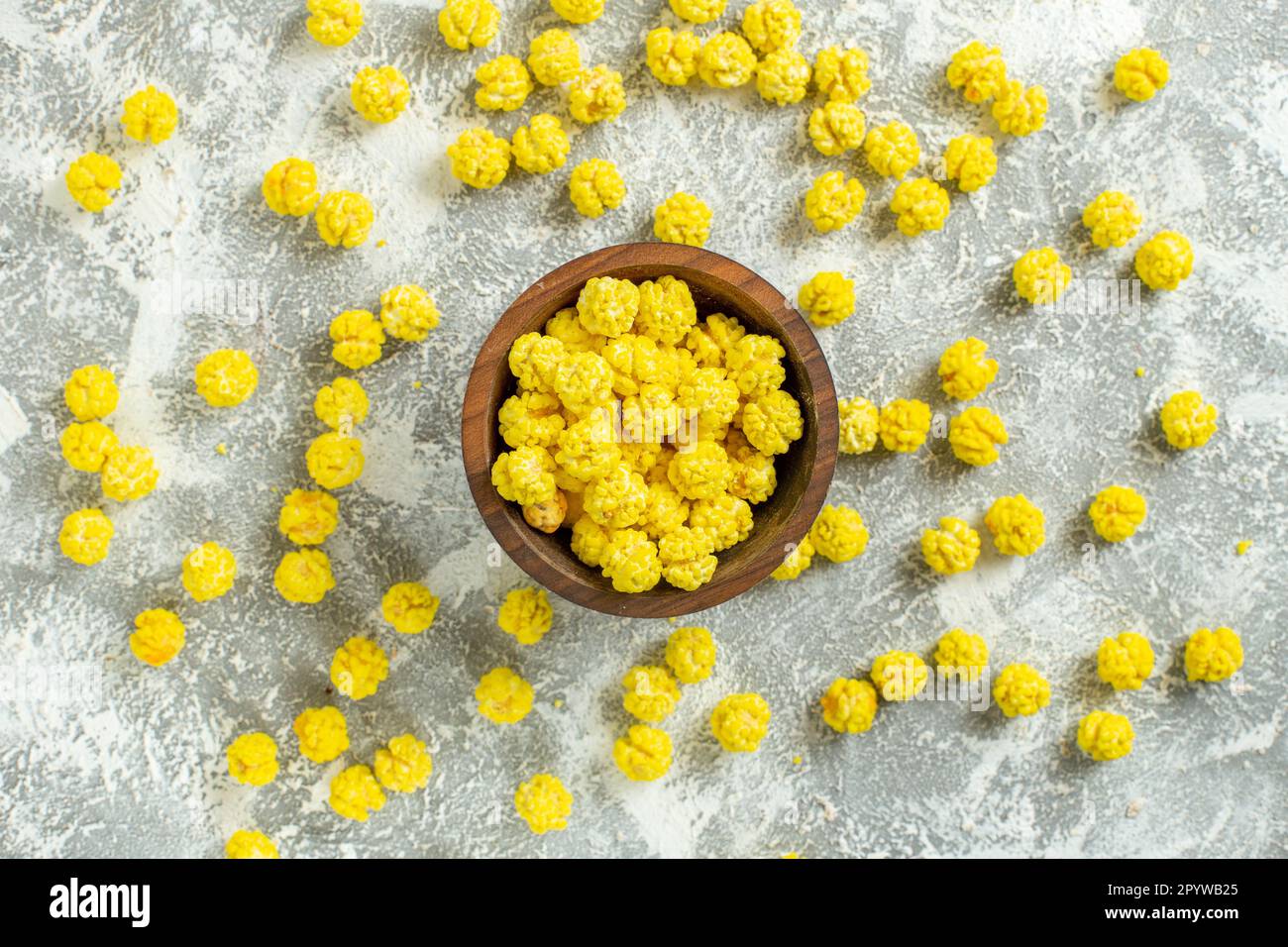 top view yellow little candies on white background color many granule ...