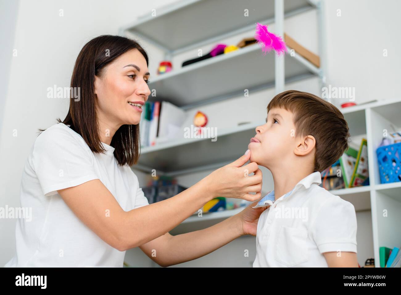 A cute child with a speech therapist is taught to pronounce the letters ...