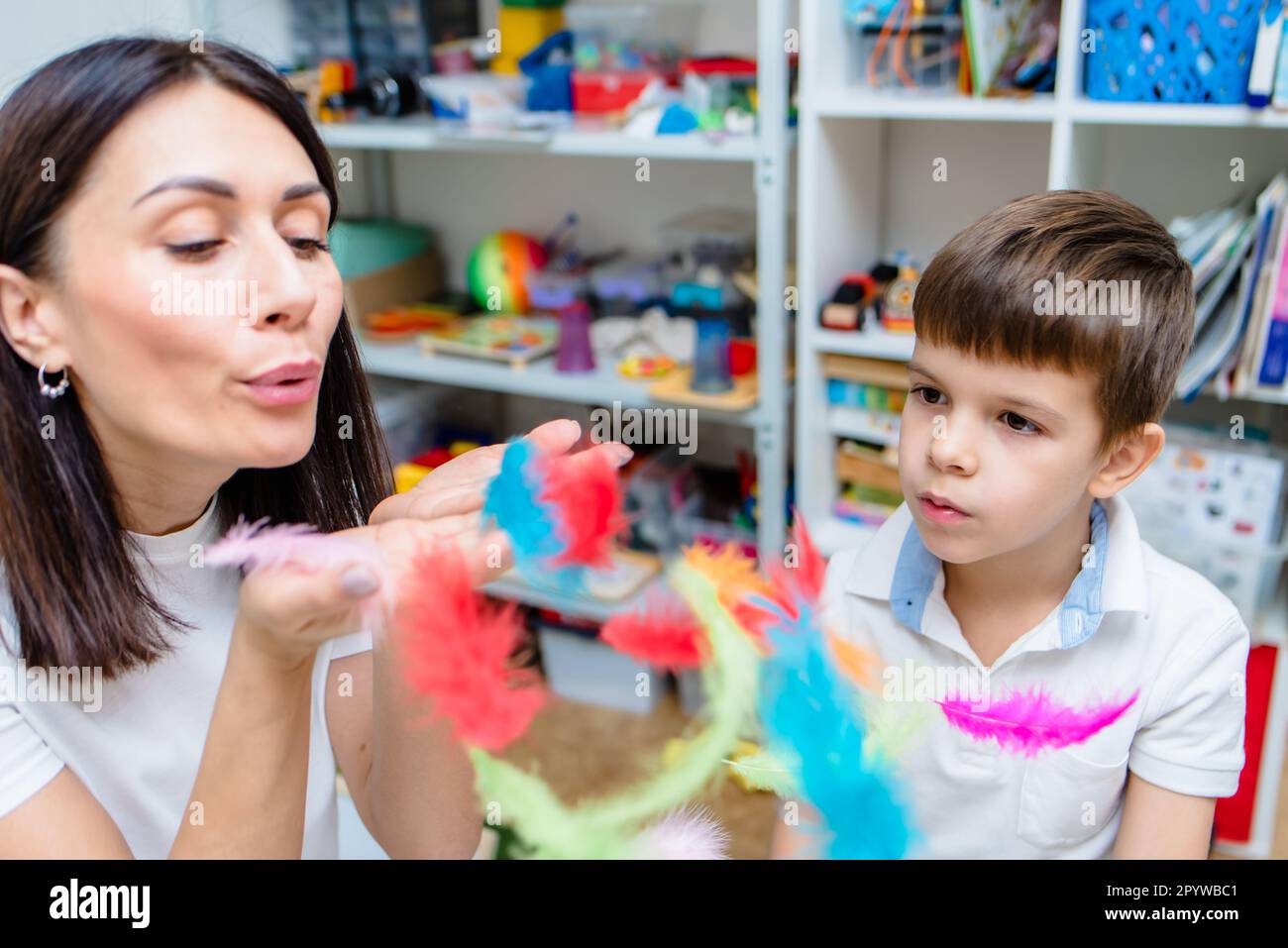 A cute child with a speech therapist is taught to pronounce the letters ...