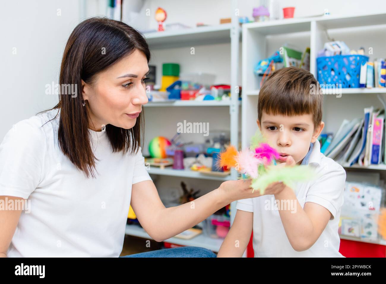 A cute child with a speech therapist is taught to pronounce the letters ...