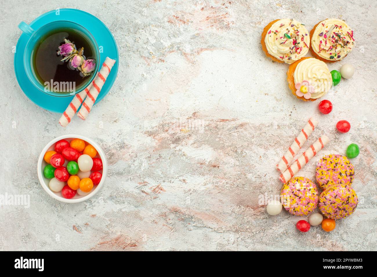 top view yummy cookie cakes with candies and cup of tea on white ...