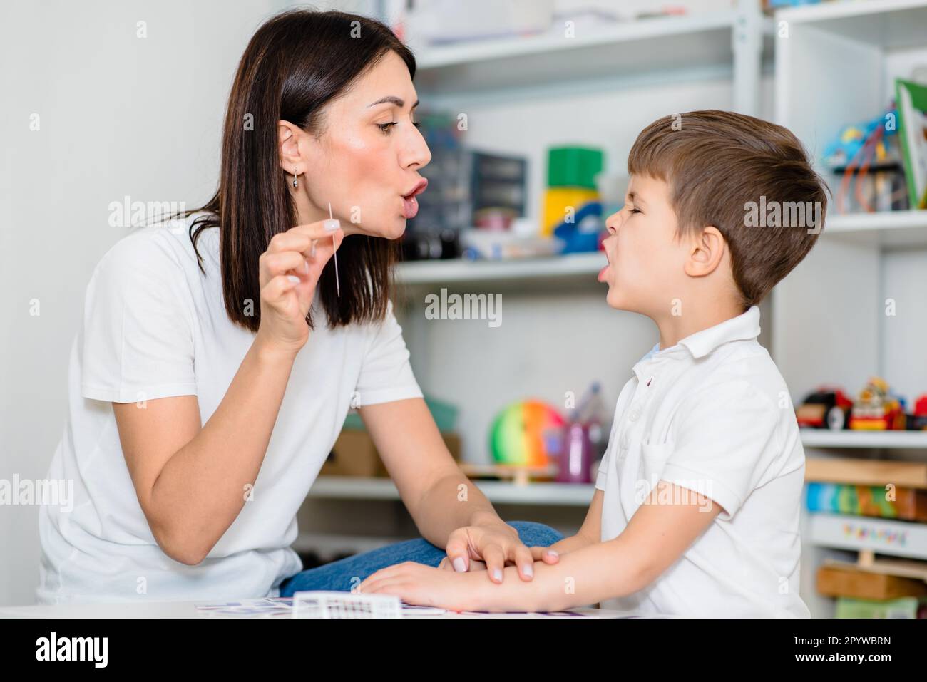 Cute woman speech therapist teaches child to pronounce words sounds and ...