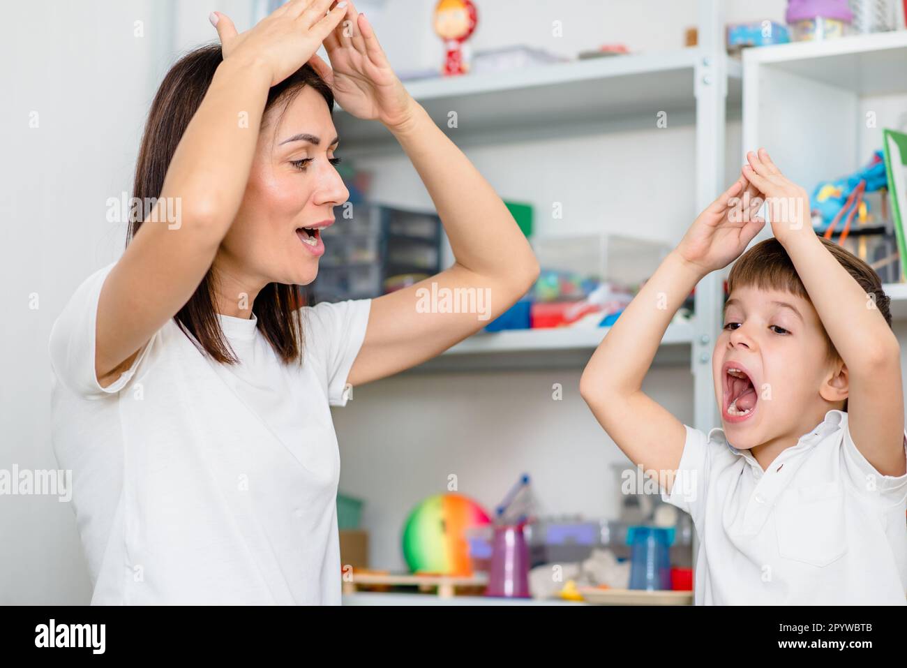 Cute woman speech therapist teaches child to pronounce words sounds and ...