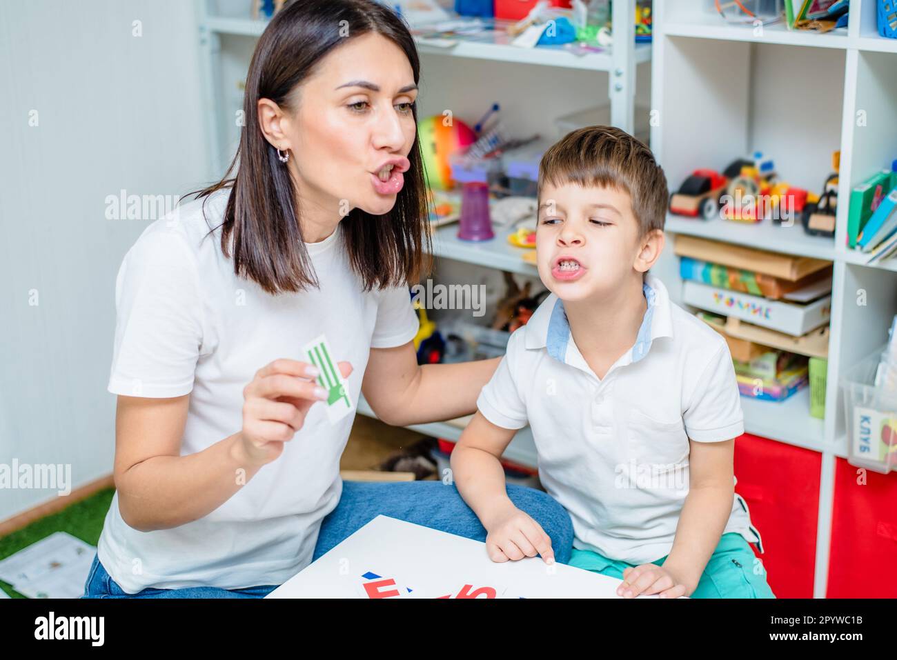 Cute woman speech therapist teaches child to pronounce words sounds and ...