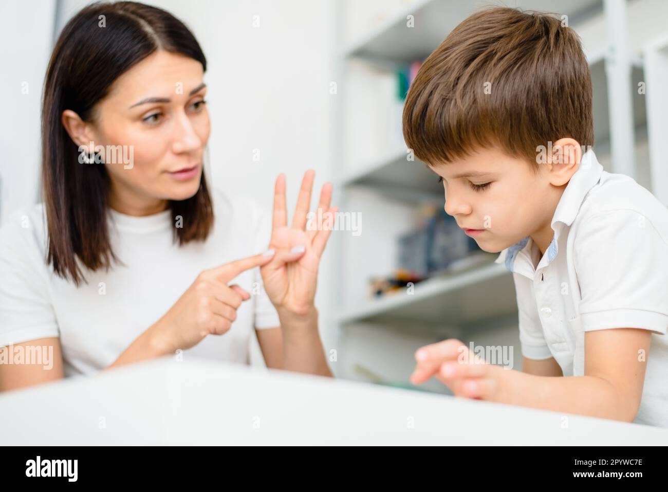 Cute woman speech therapist teaches child to pronounce words sounds and ...