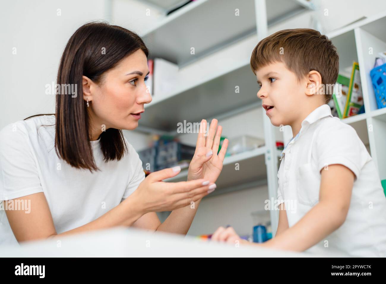 Cute woman speech therapist teaches child to pronounce words sounds and ...