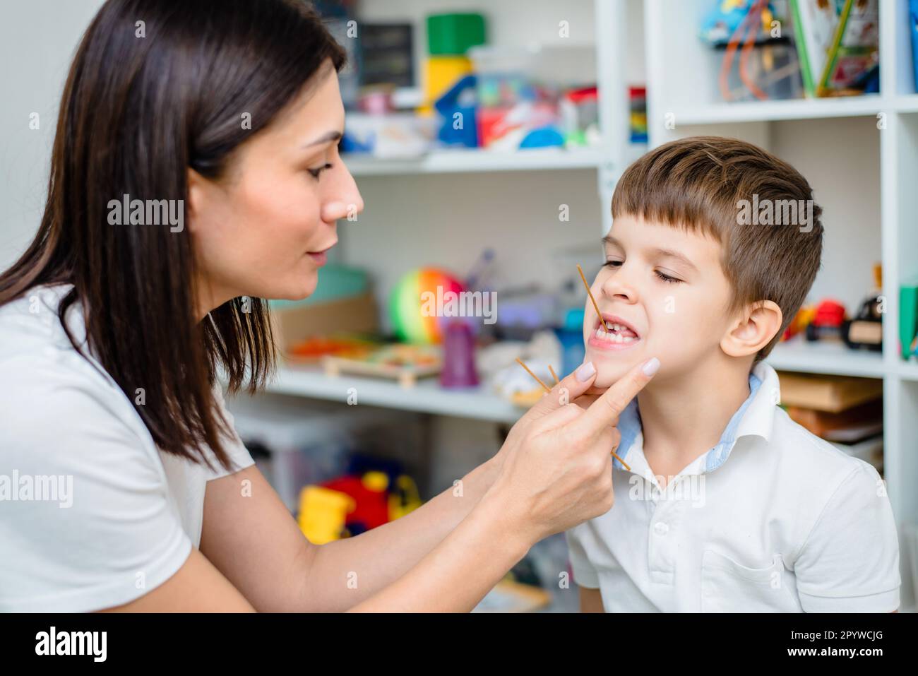 Cute woman speech therapist teaches child to pronounce words sounds and ...