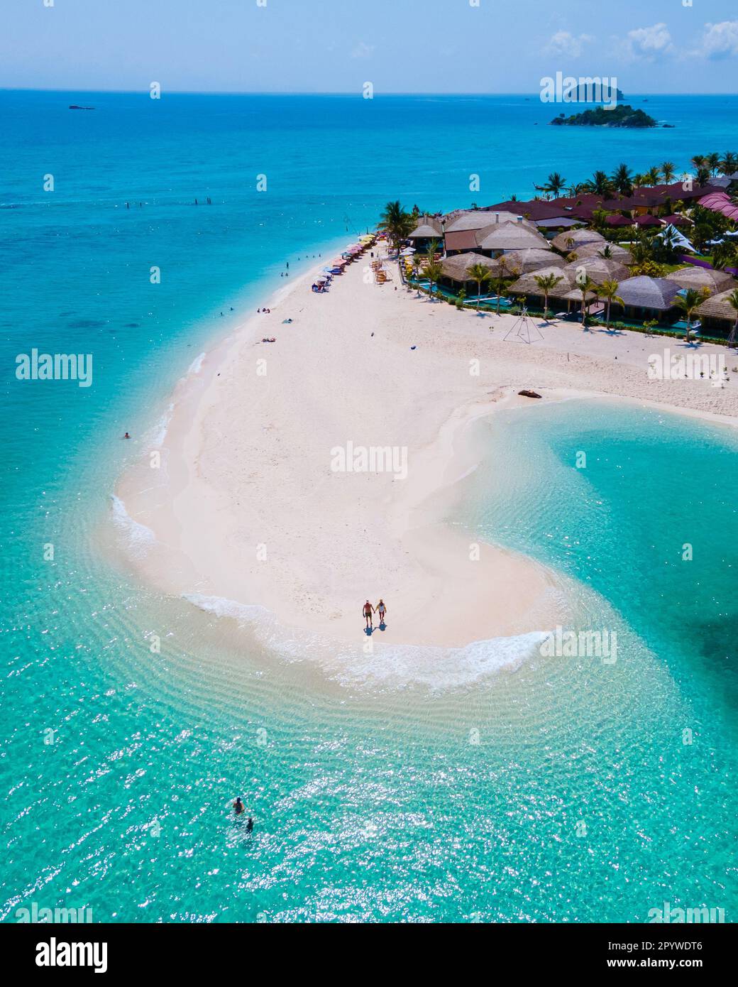 men and women walking on a sandbar in the ocean of Koh Lipe Southern ...