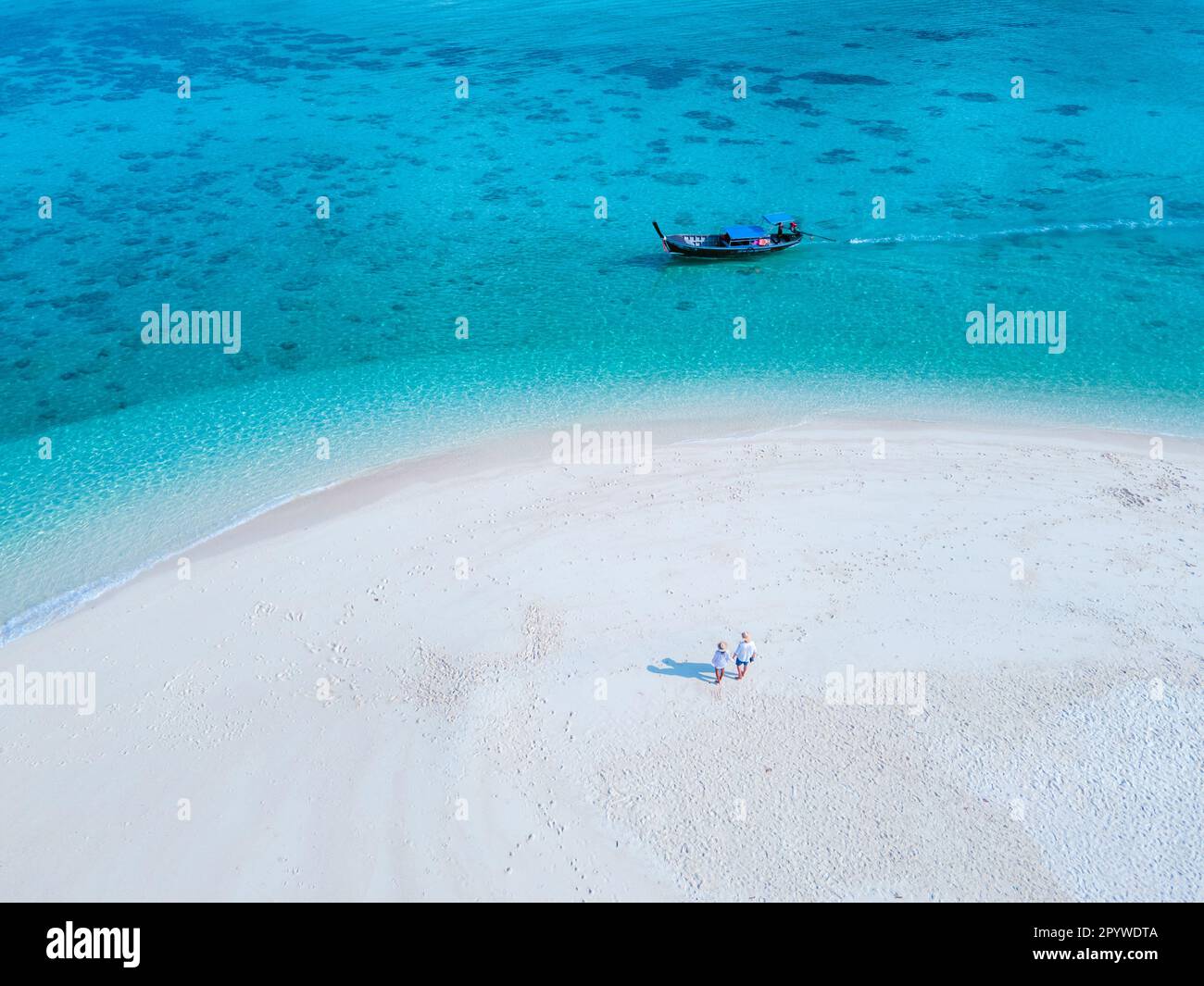 men and women walking on a sandbar in the ocean of Koh Lipe Southern Thailand during vacation. a ...