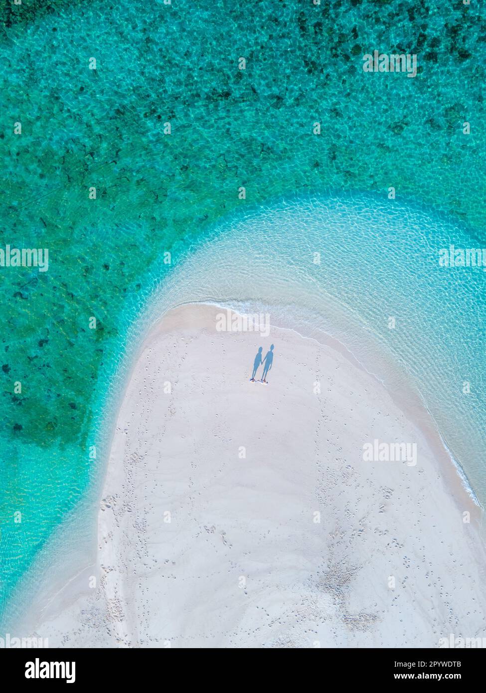 men and women walking on a sandbar in the ocean of Koh Lipe Southern ...
