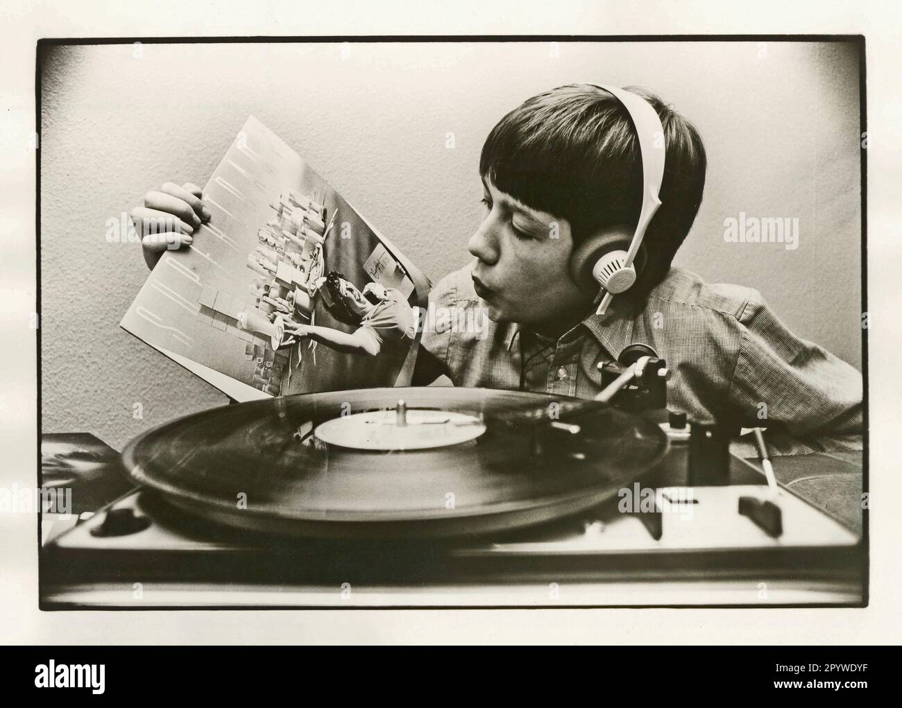 Young man with a record of Supertramp in front of his record player ...
