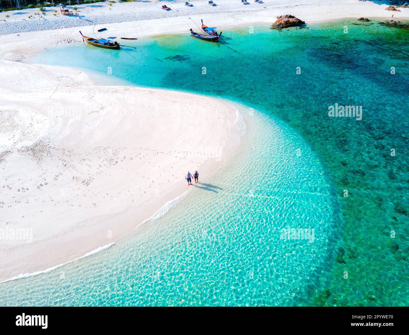 men and women walking on a sandbar in the ocean of Koh Lipe Southern ...
